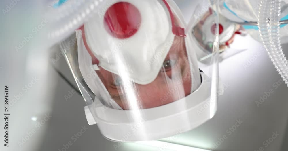 The doctors in covid safety uniform with masks putting an oxygen mask ...