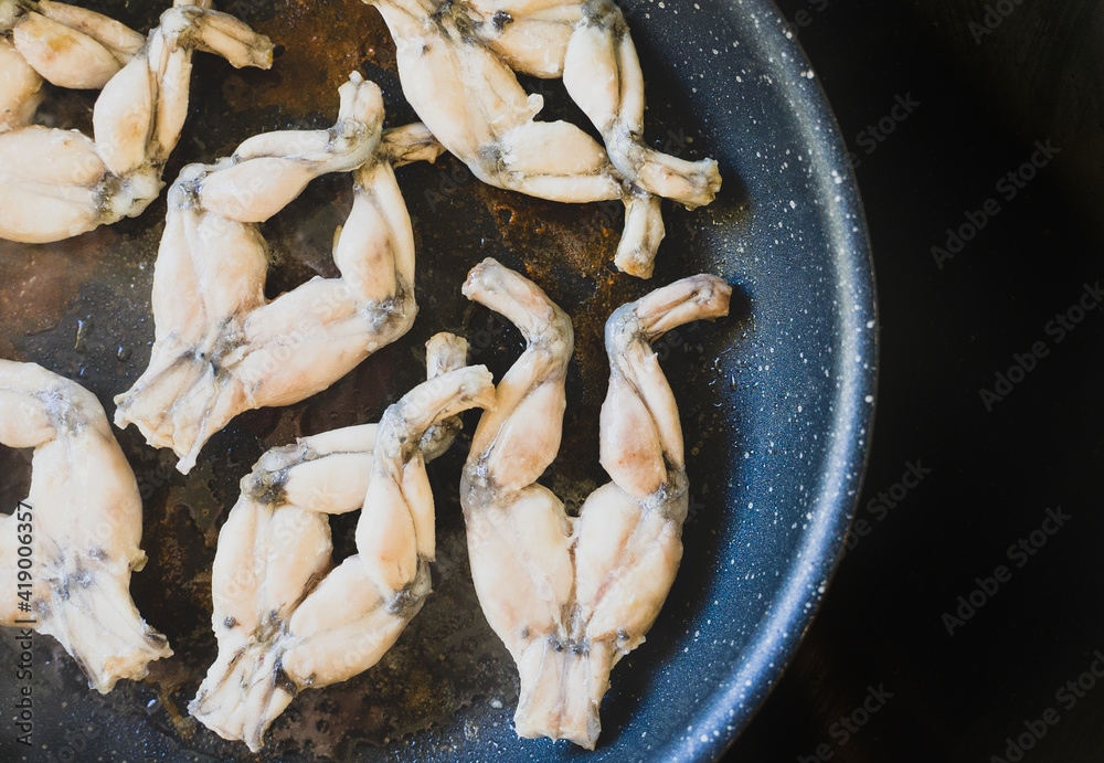 Traditional cooking of fried frog legs on pan. Top view. Stock Photo ...