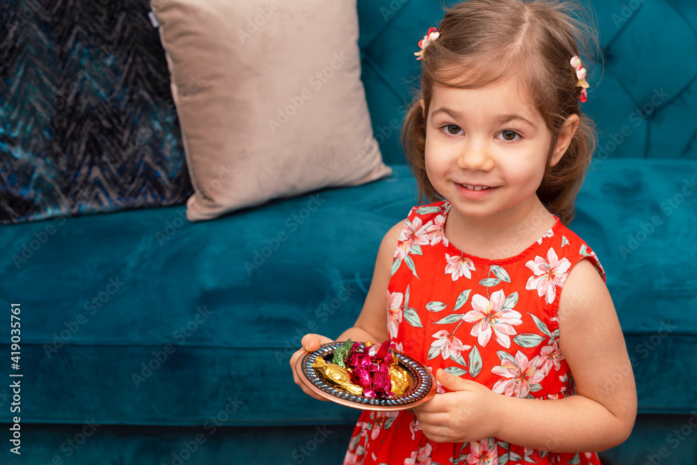 Foto de Portrait of cute baby girl holding candies from during Ramadan ...