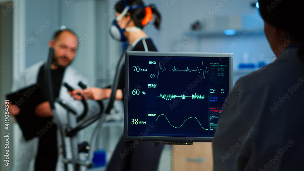 Foto de Medical researcher examining EKG image showing on monitor while ...