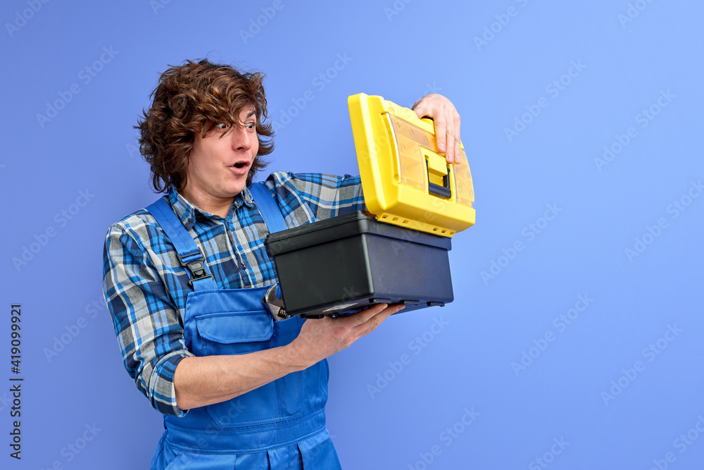 builder man opening tools box with shocked expression on face, curly ...