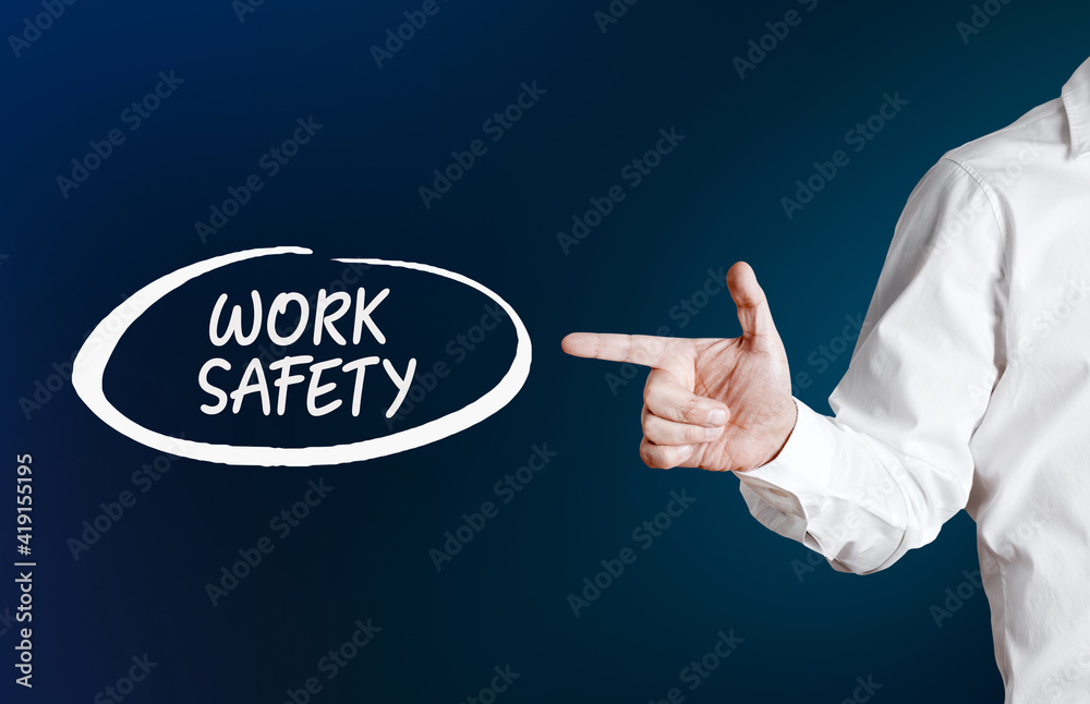Male hand points to the word work safety on blue background. Work or ...