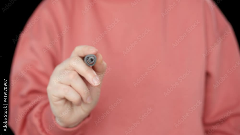 Female hand writing check mark with marker on transparent board front ...