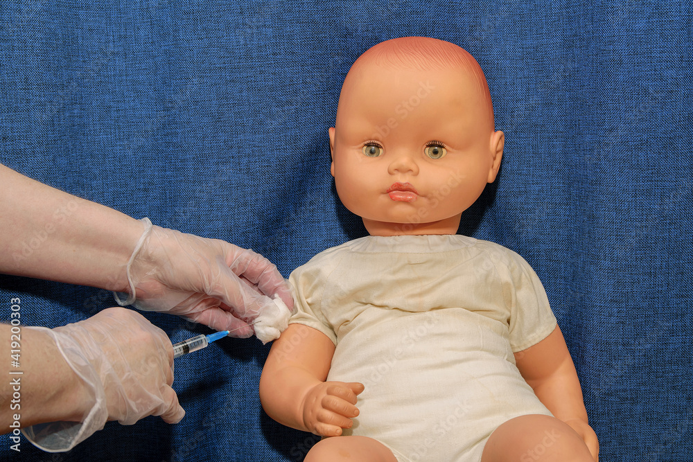 Fotka „Hospital game, woman's hands as if giving a shot to a baby doll ...