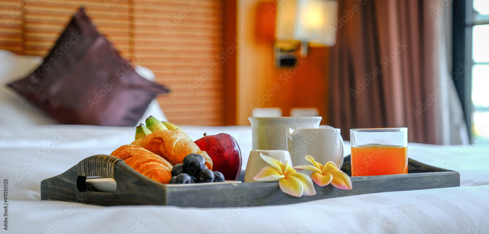 Breakfast in a tray on the bed in the luxury hotel room ready for ...