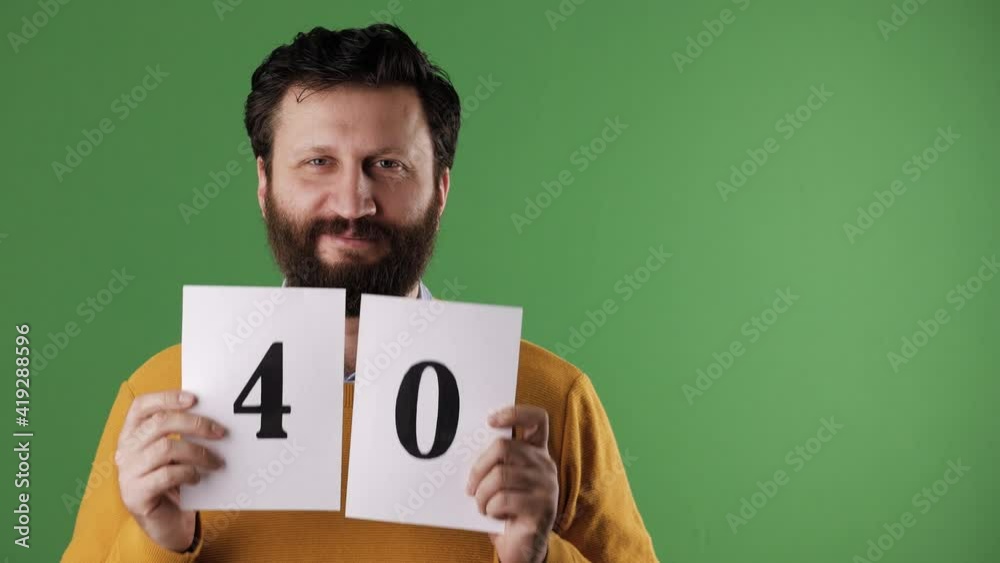 Man holding number 40 sign. Cheerful white bearded good-looking man in ...
