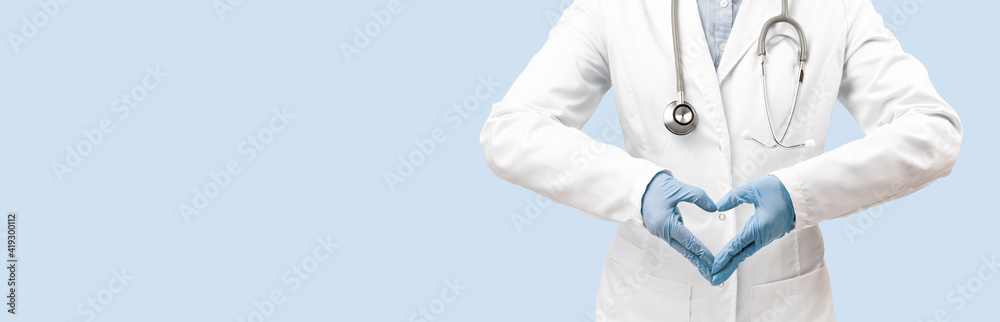 Female doctor in white uniform forms a heart shape with her hands ...