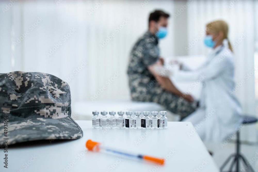 Military vaccination and immunization. Bottles with vaccine and doctor ...