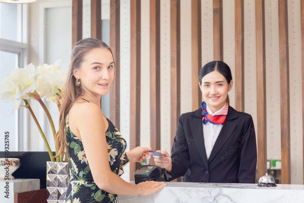 Happy guest and receptionist at hotel reception, Young travellers ...