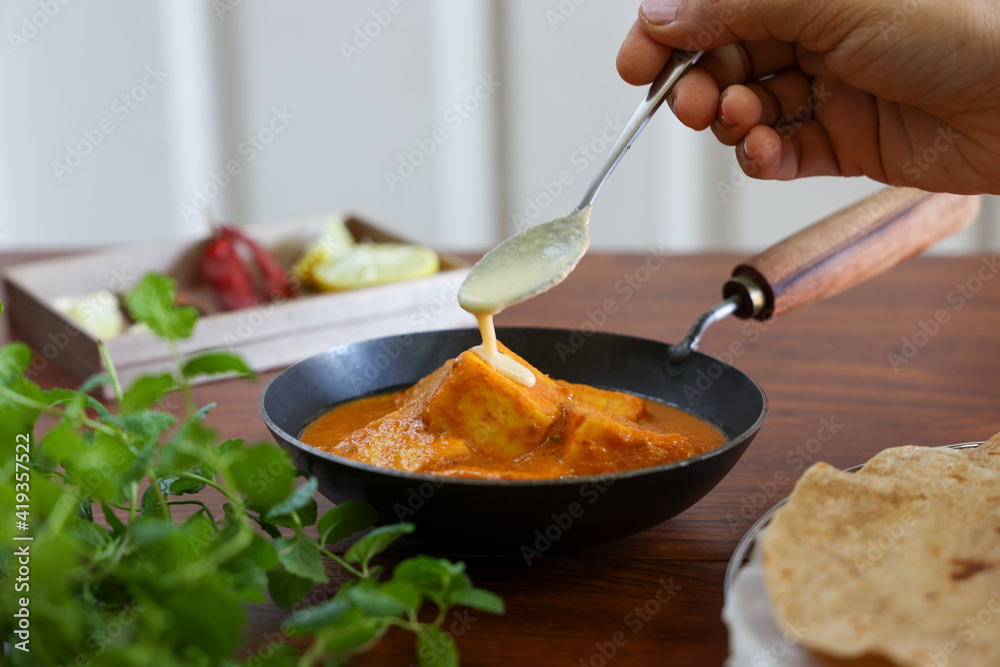 Paneer butter masala , pouring cream on Paneer tikka masala curry Delhi ...