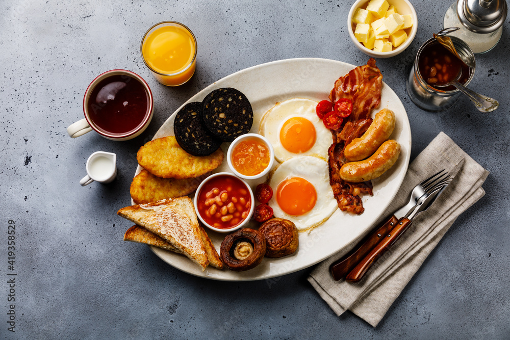 Full fry up English breakfast with fried eggs, sausages, bacon, black ...