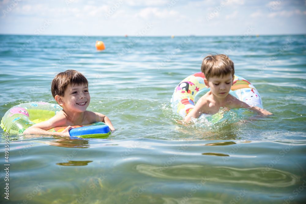 Child in swimming pool floating on toy ring. Kids swim. Colorful ...