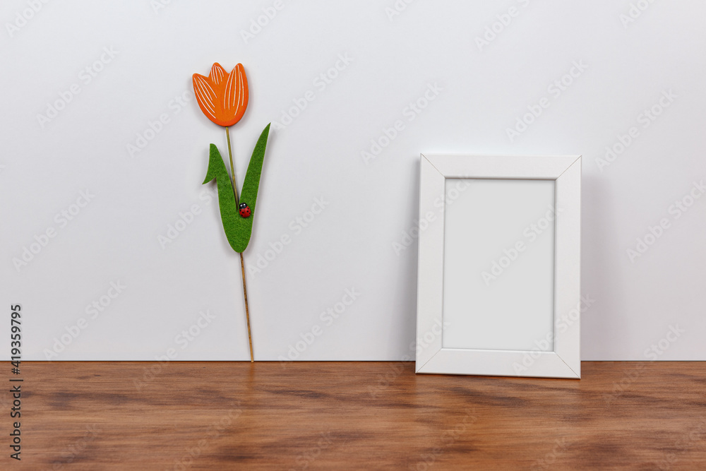 Minimalist still life of a customizable picture frame and wooden tulip ...