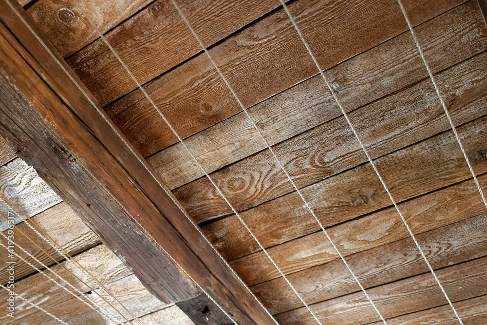 Stary strych. Dach z drewnianych belek i desek. Sznurki na bieliznę i ...