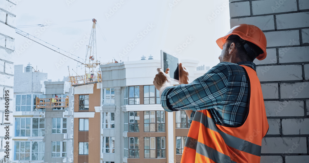 Builder taking photo with digital tablet on construction site Stock ...