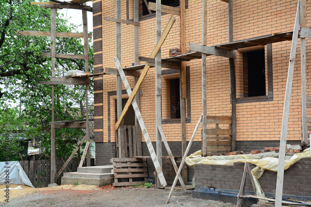 A view of a new brick house under construction with scaffolding ...