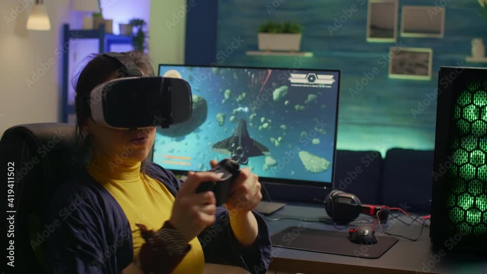 Winner gamer wearing virtual reality goggles, playing space shooter ...