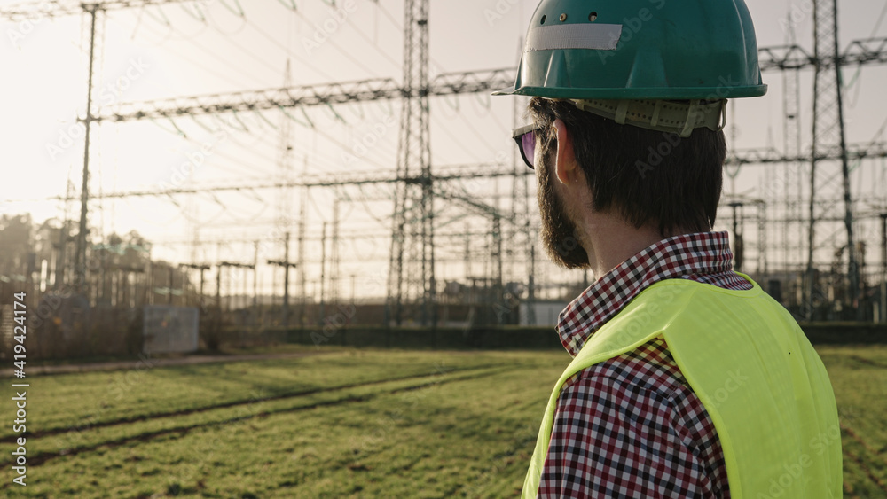 Electrical engineer wearing a helmet and safety vest working with ...