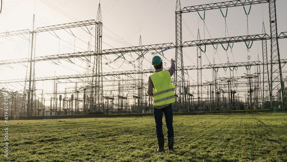 Electrical engineer wearing a helmet and safety vest working with ...