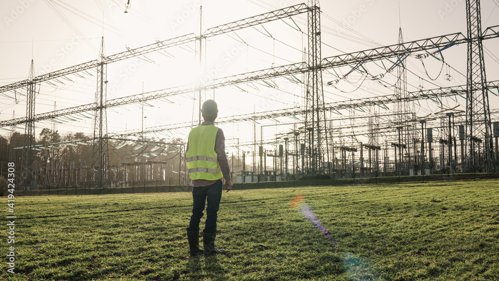 Electrical engineer wearing a helmet and safety vest working with ...