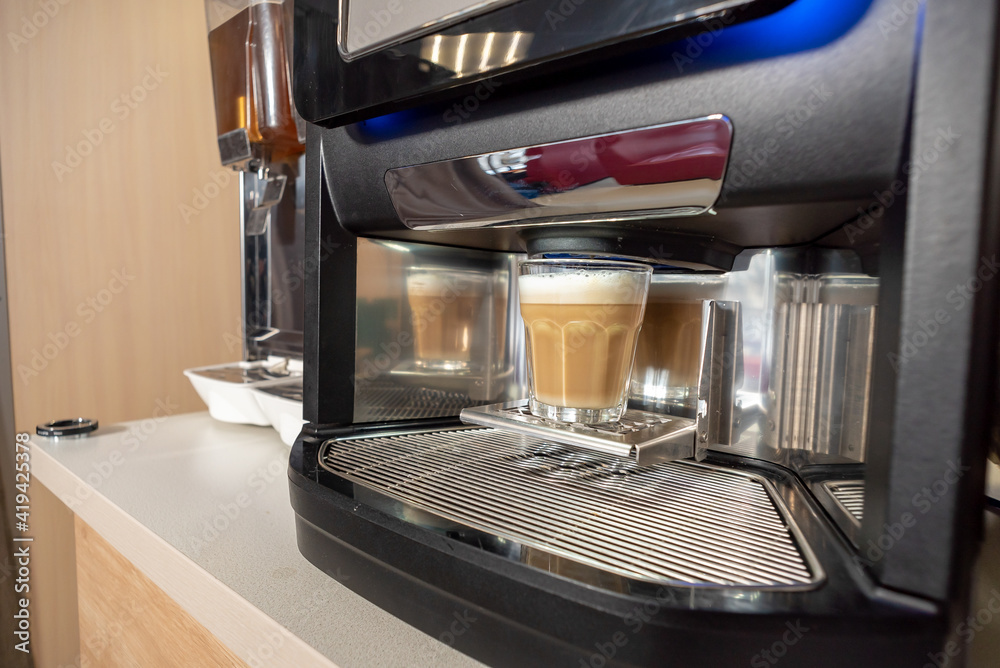 bean coffee with milk, freshly made in a coffee machine, ready to drink ...