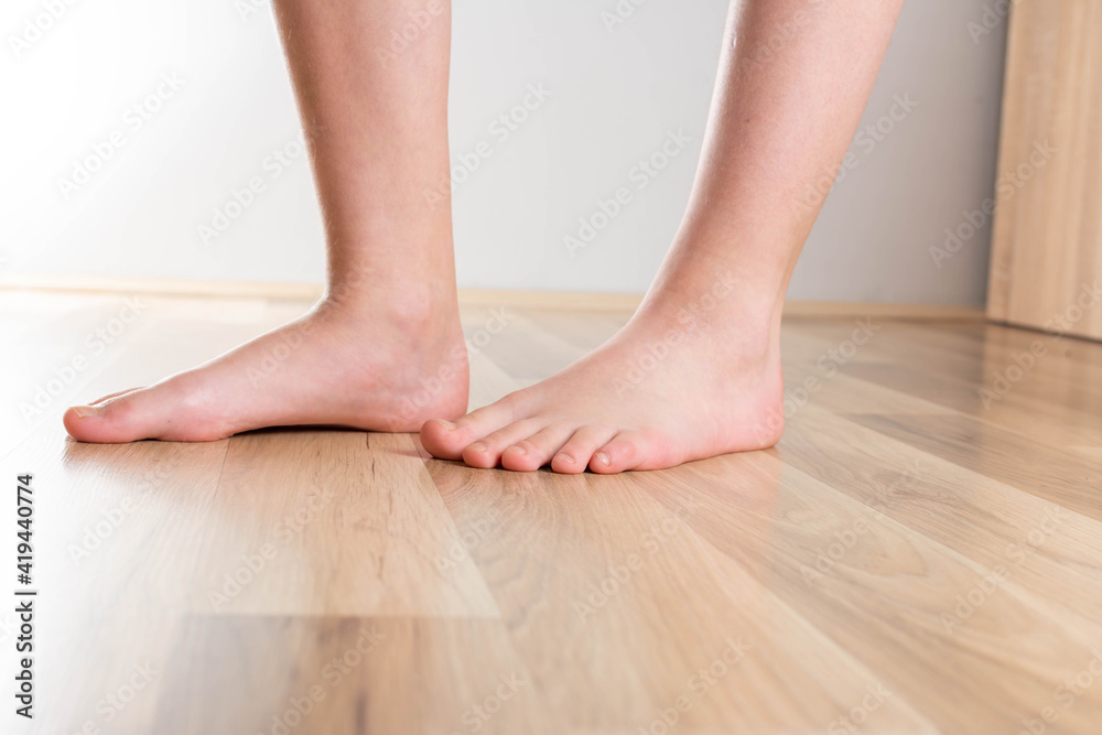 Children's bare feet. Child's bare feet on the wooden floor. Side-view ...