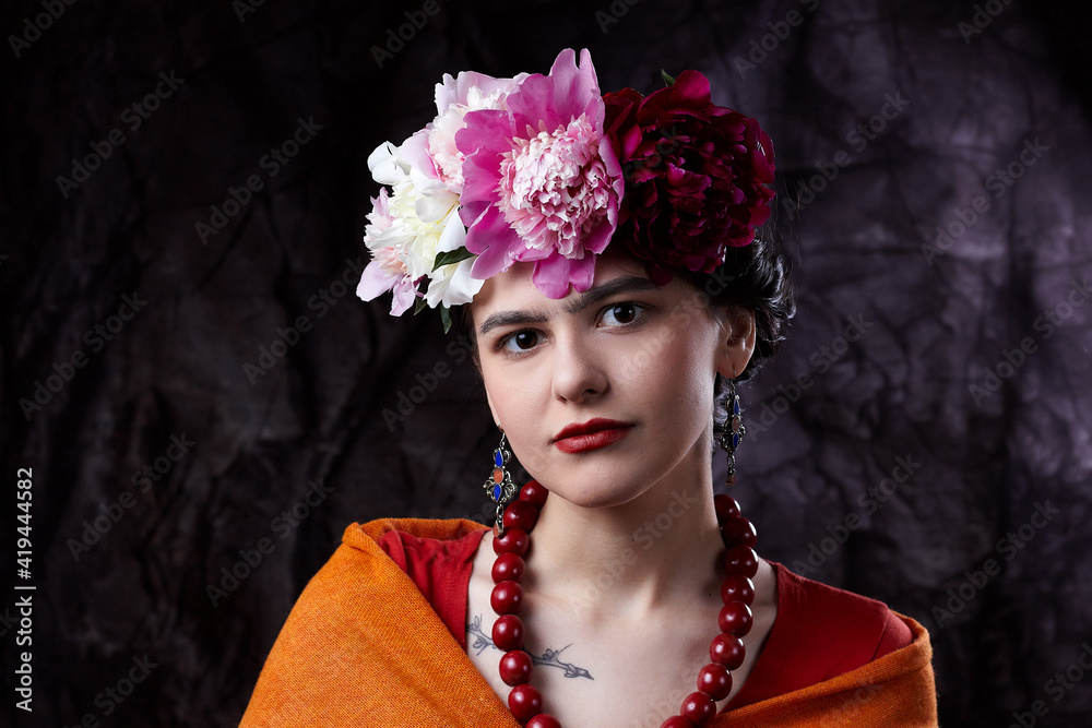 The beautiful girl brunette with red lips with a wreath of peonies on ...