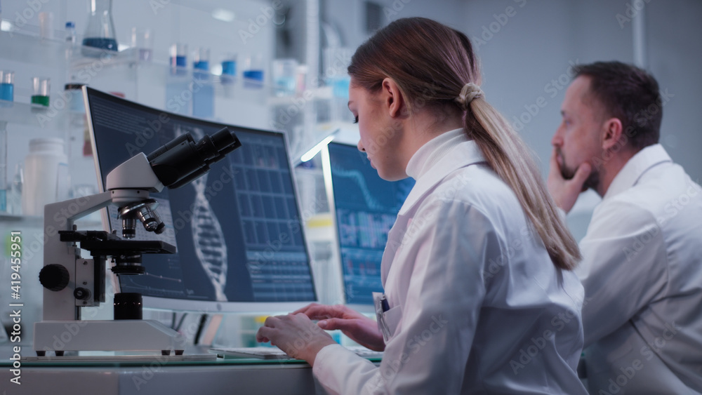 Diverse scientists studying human skeleton and DNA. Using computers and ...