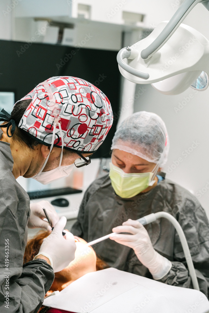 Professional dentist applying anesthetic injection to patient while ...