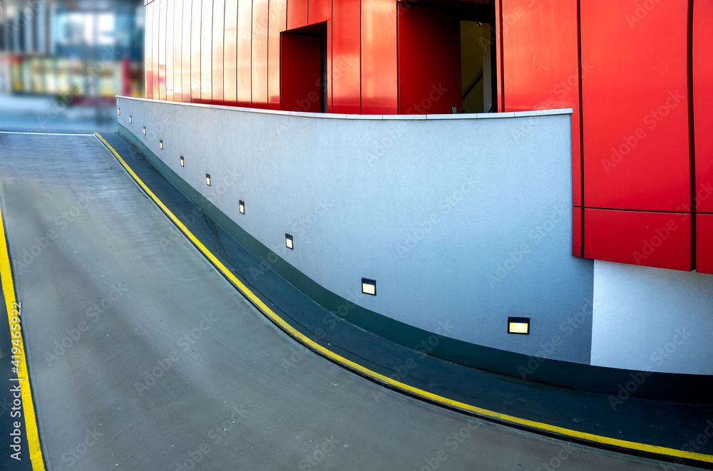 Entrance to an underground car park with modern red and grey wall ...