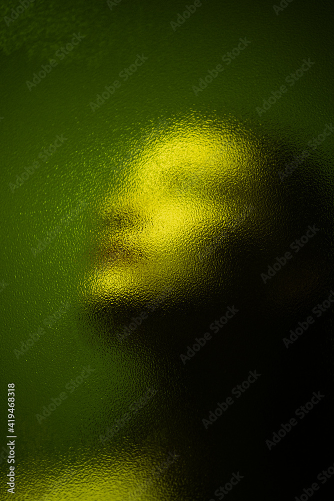 Headshot of anonymous person standing in room with dim green light and ...