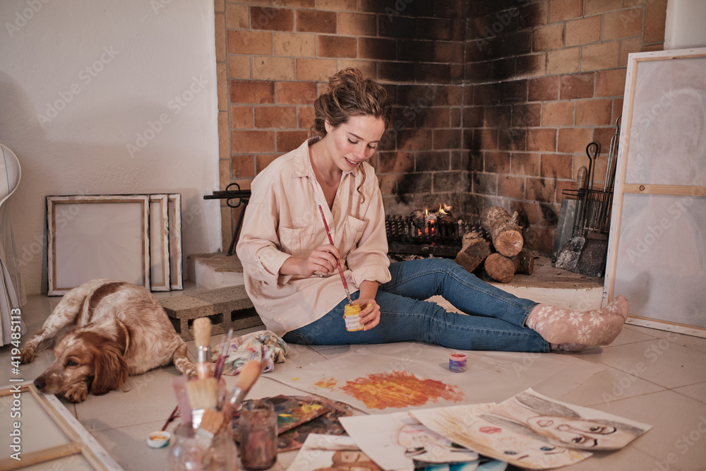 Foto de Side view of female artist sitting on floor with sleeping ...