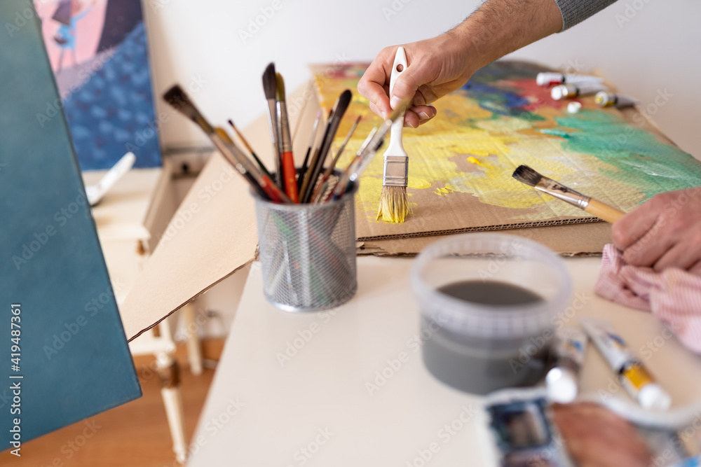 Crop unrecognizable male painter using professional brush during ...