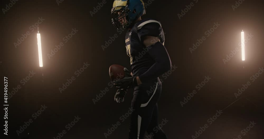 Strong rugby player with ball in studio. Muscular male rugby player in ...