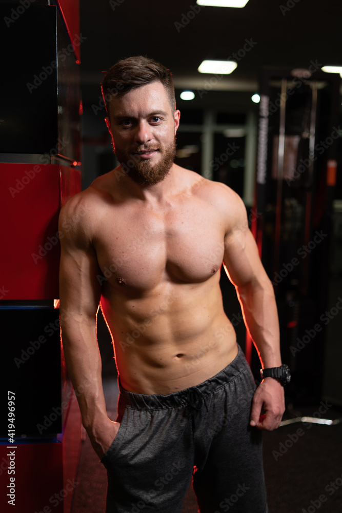 Strong man with muscular body type posing in modern sports hall. Stock ...