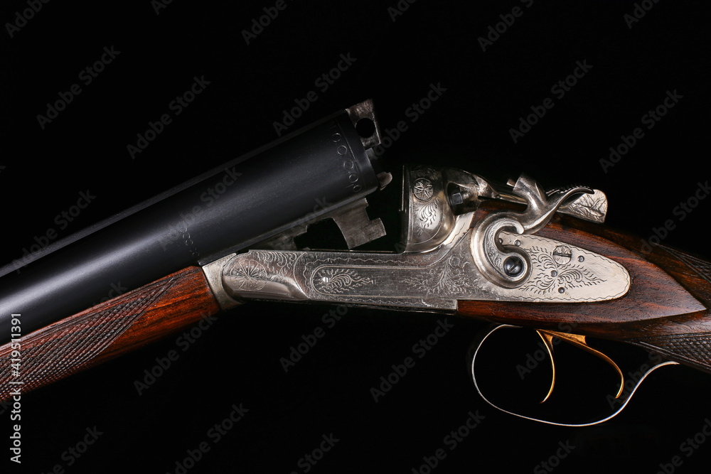 Details of an elegant double-barreled hunting classic shotgun on a black background close-up ...