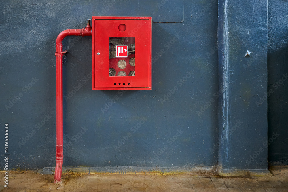 Fire hose in red box. Pipe roll for fire emergency in red metal cabinet ...