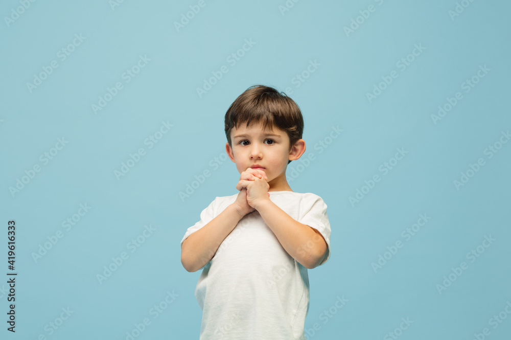 Hopeful. Happy, smiley little caucasian boy isolated on blue studio ...