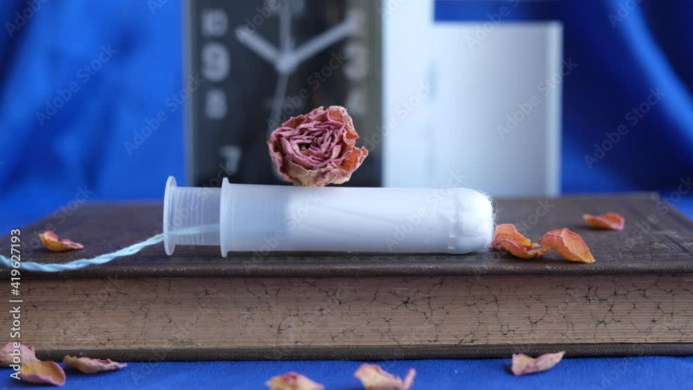 menopause concept. dried red rose lies on a woman tampon. dried rose ...