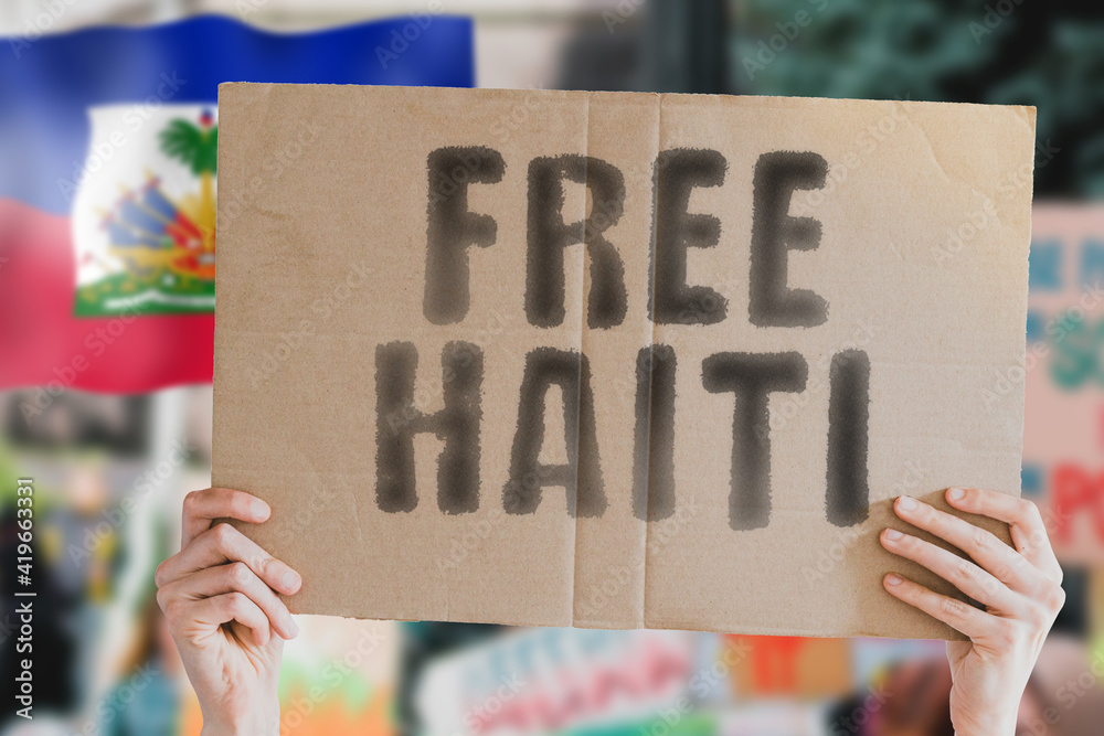 The phrase " Free Haiti " on a banner in men's hand with blurred ...