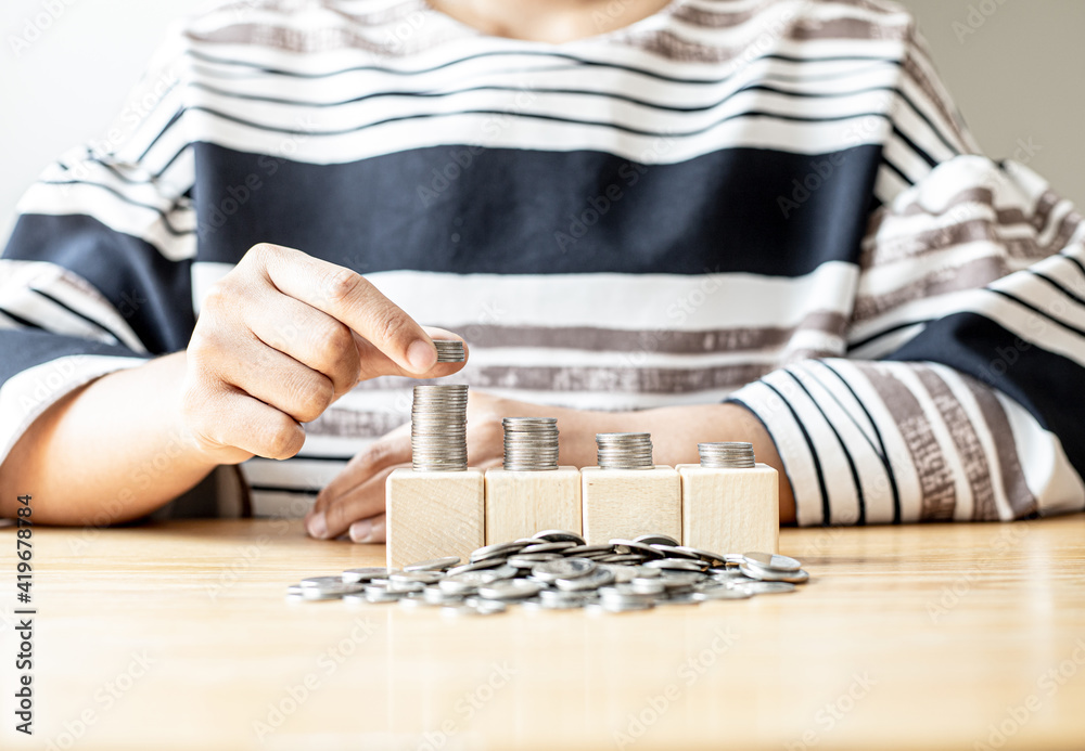 Women are stacking coins on a pile of coins nestled on four rows of ...