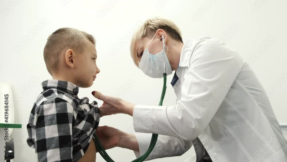 Little boy having a check up at pediatrician. The doctor is pulping and ...