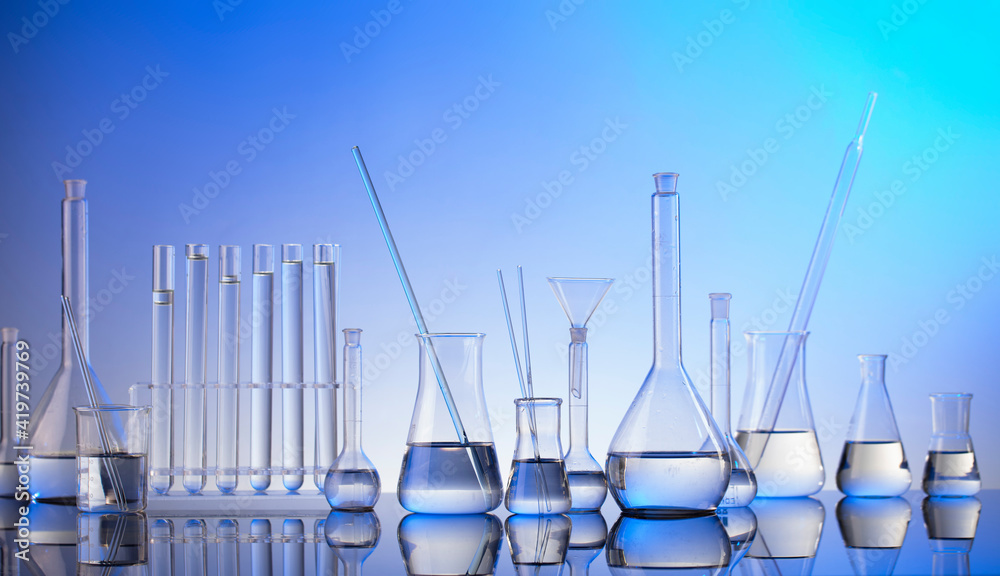 Laboratory investigations. Glass tubes and beakers on blue background ...