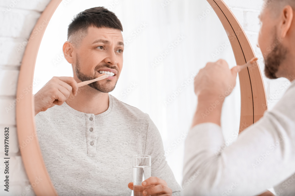 Man suffering from pain while brushing teeth in morning Stock Photo ...