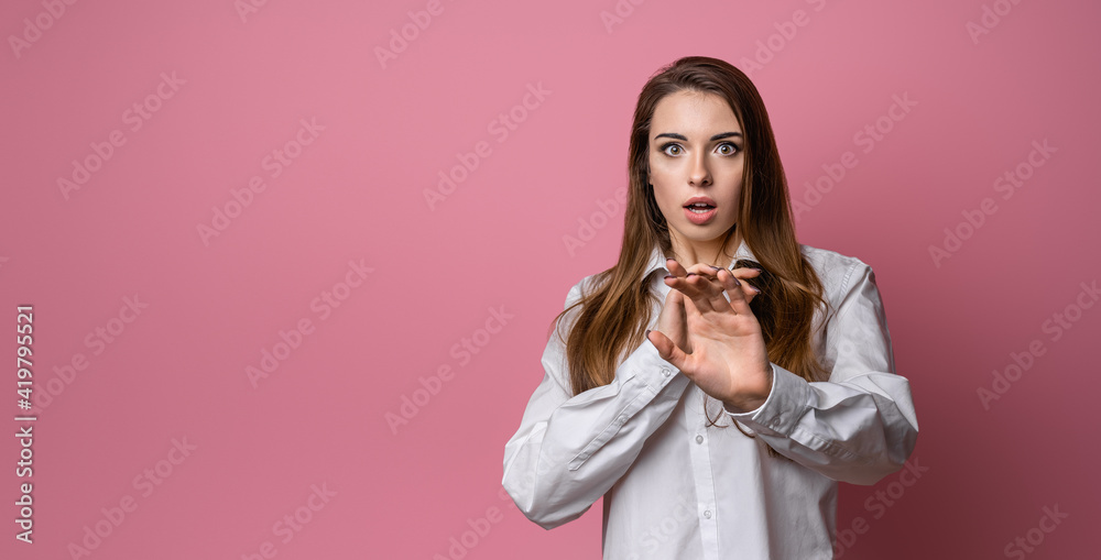 Portrait of startled young brunette woman raising hands and gasping ...