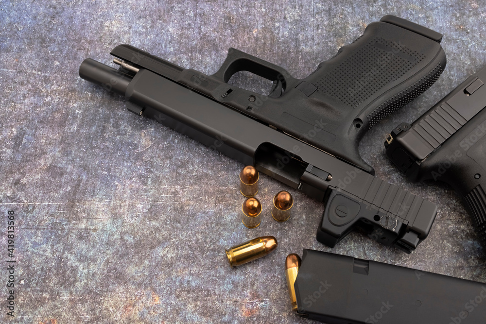 .45 Semi automatic pistol handgun and bullet magazine on texture ...