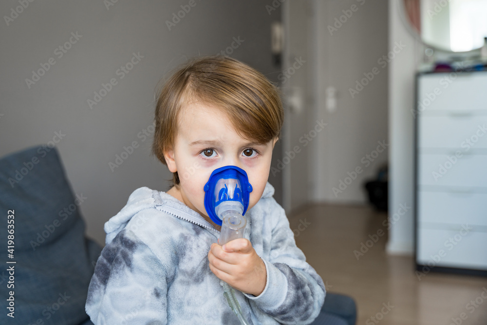 Sick child boy doing inhalation at home, toddler doing therapy aerosol ...