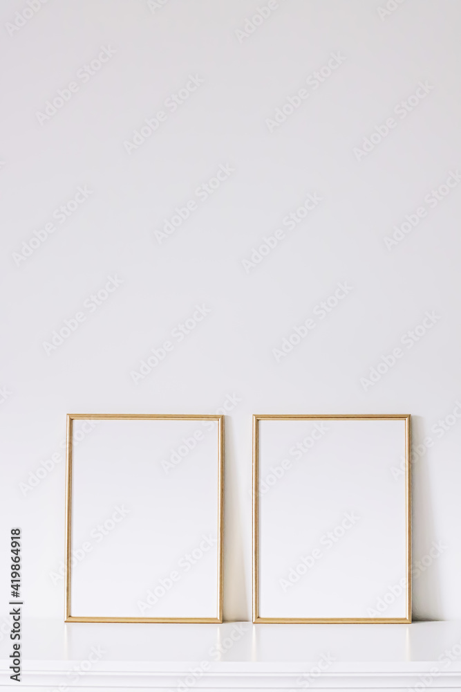 Two golden vertical frames on white furniture, luxury home decor and ...