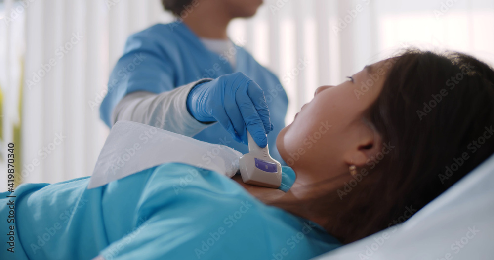 Woman doctor examining patient child girl thyroid gland using ...