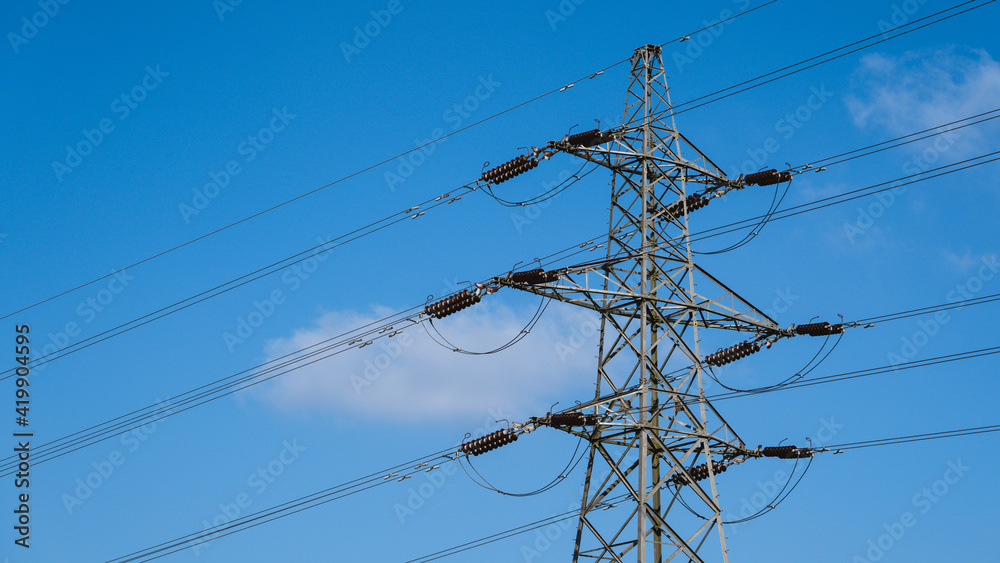 High voltage power lines on a blue sky background Stock Photo | Adobe Stock